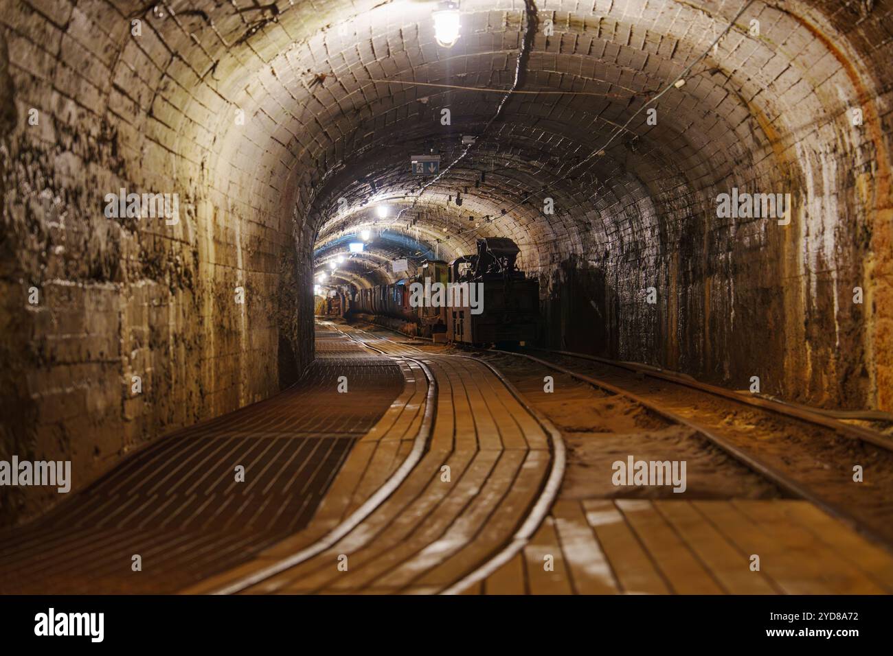 A Dark, Spooky Abandoned Mine Tunnel with Rusty Rails and Stone Walls ...