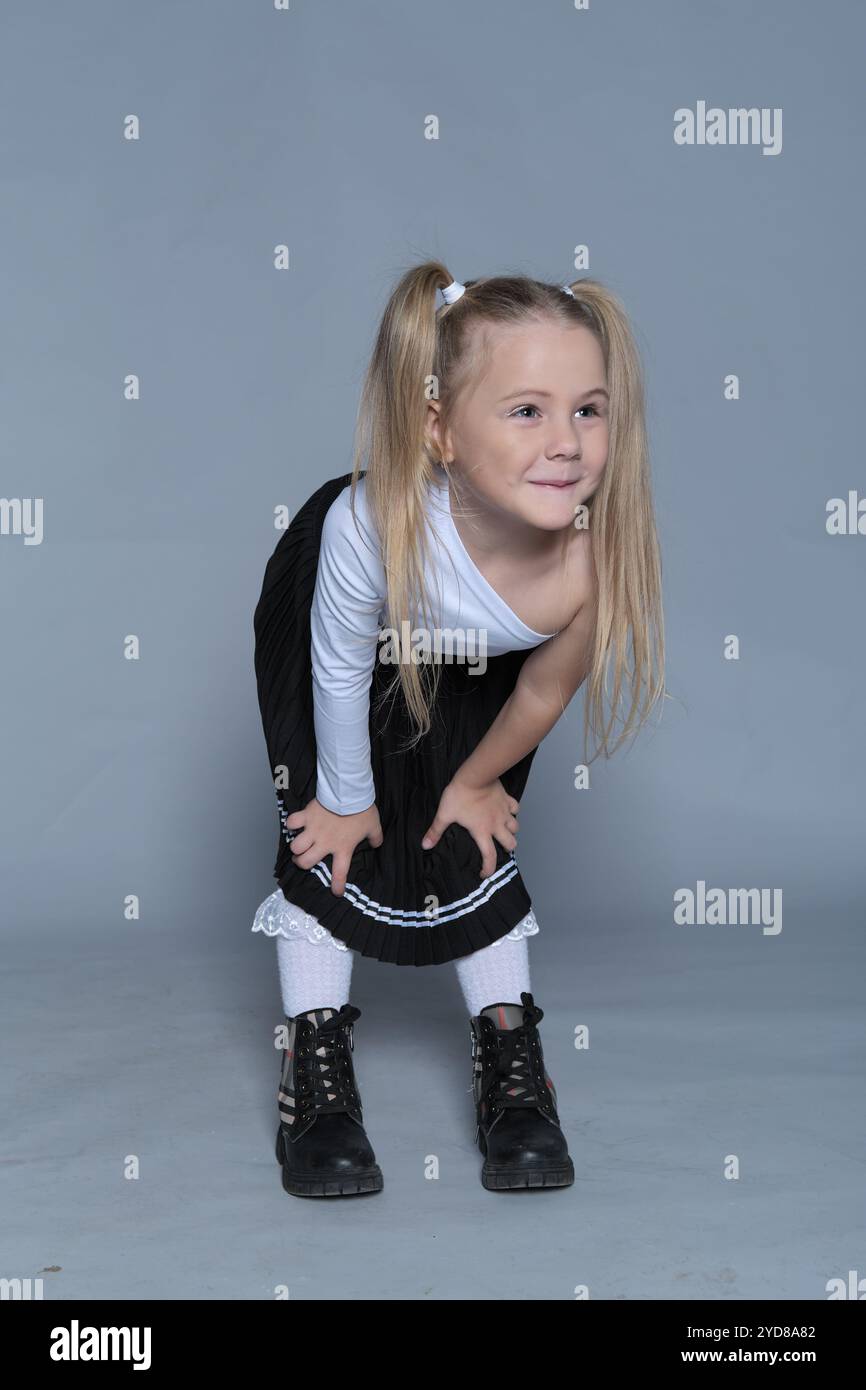 energetic 5-year-old model leans forward with a playful grin, dressed ...