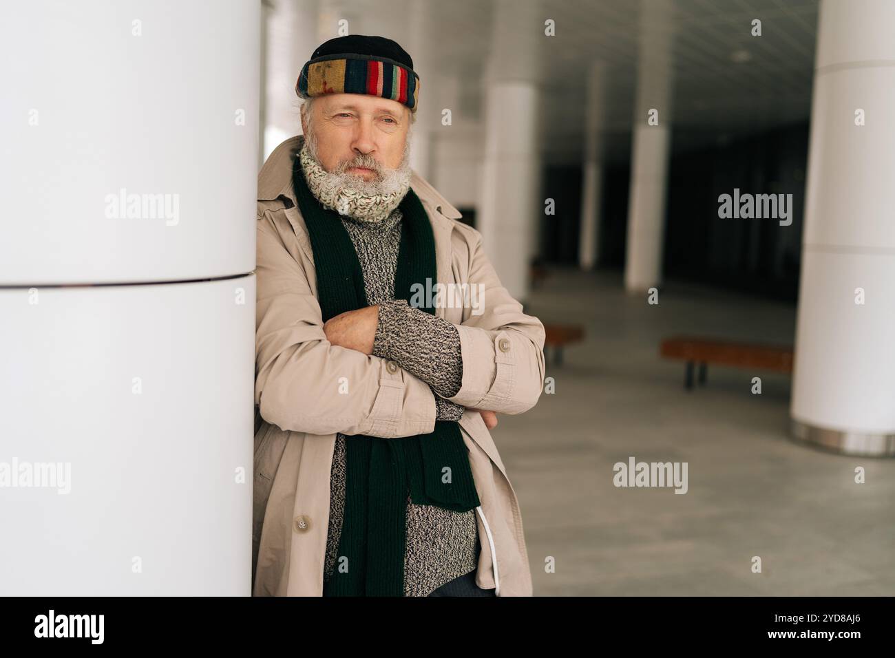 Portrait of bearded senior homeless man wearing worn clothes and scarf ...