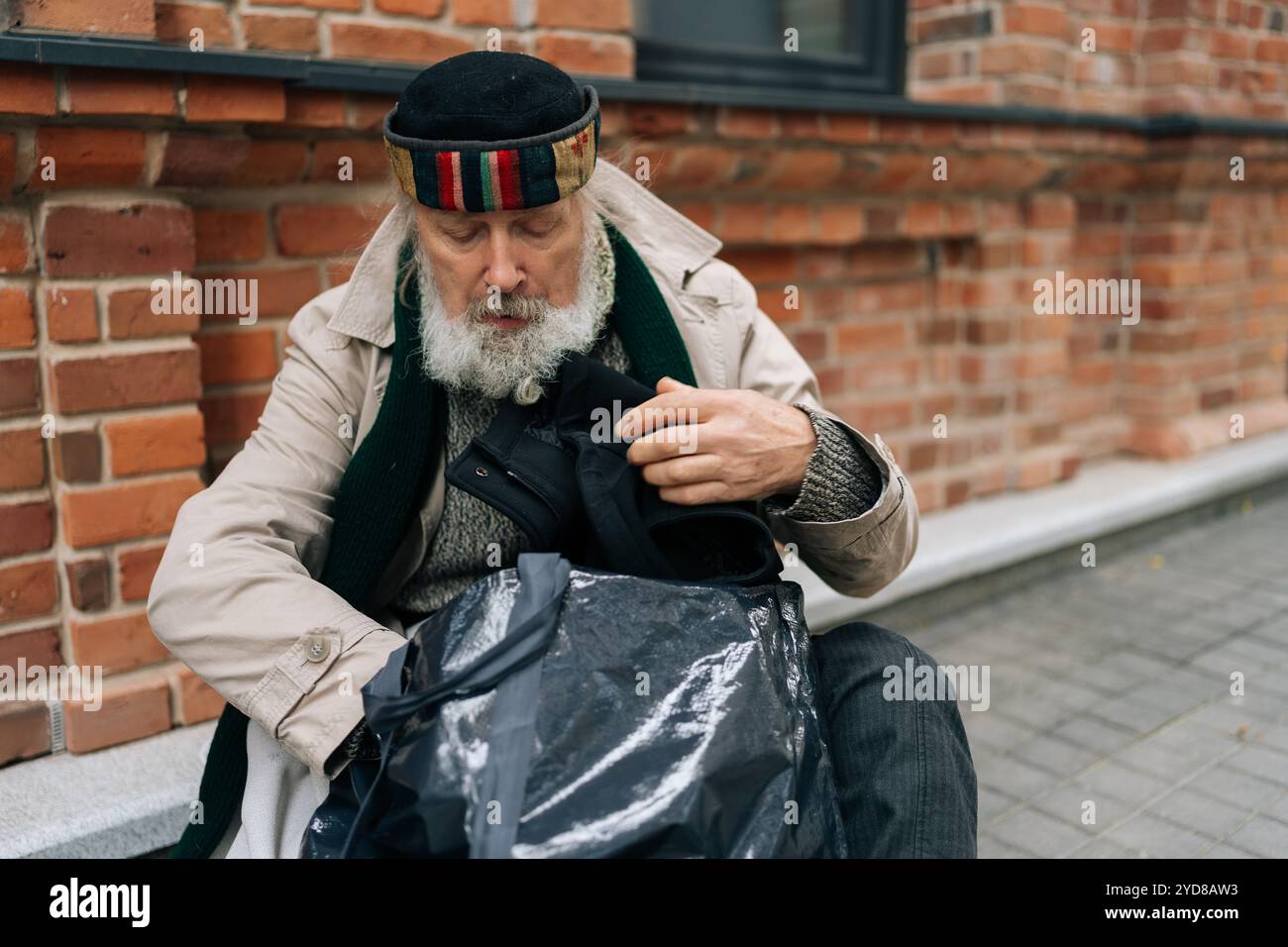 Portrait of homeless man with long white beard searching through ...