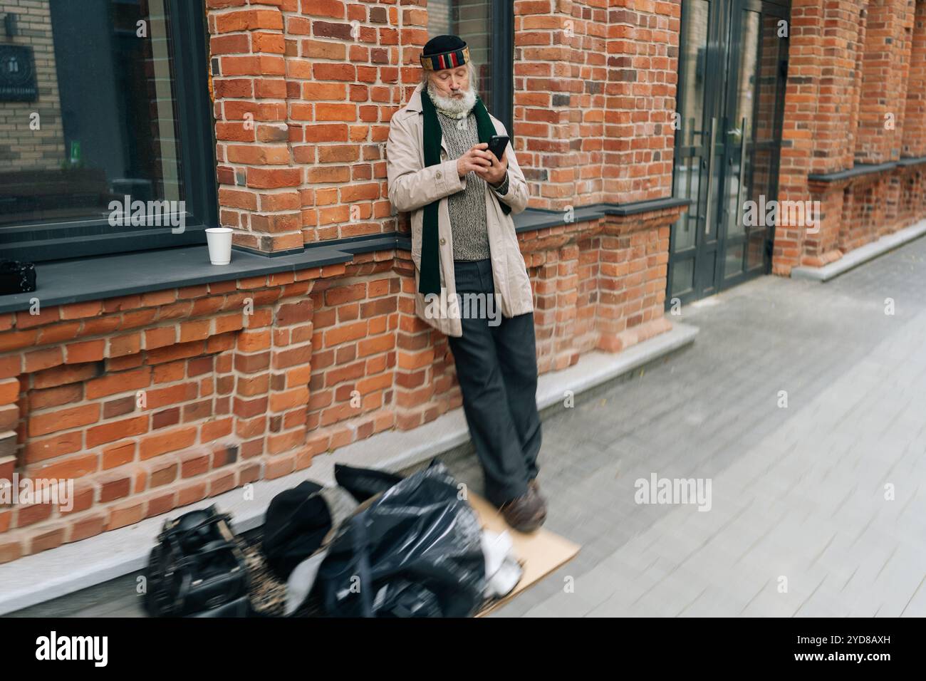 Full length vertical portrait of tired senior homeless man with beard ...