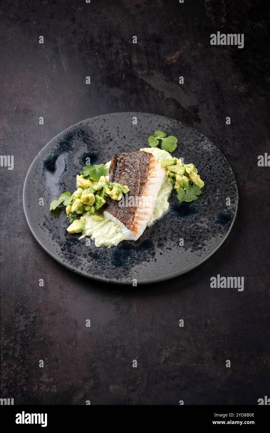 Fried skrei cod fish filet with mashed potato cream and avocado served ...