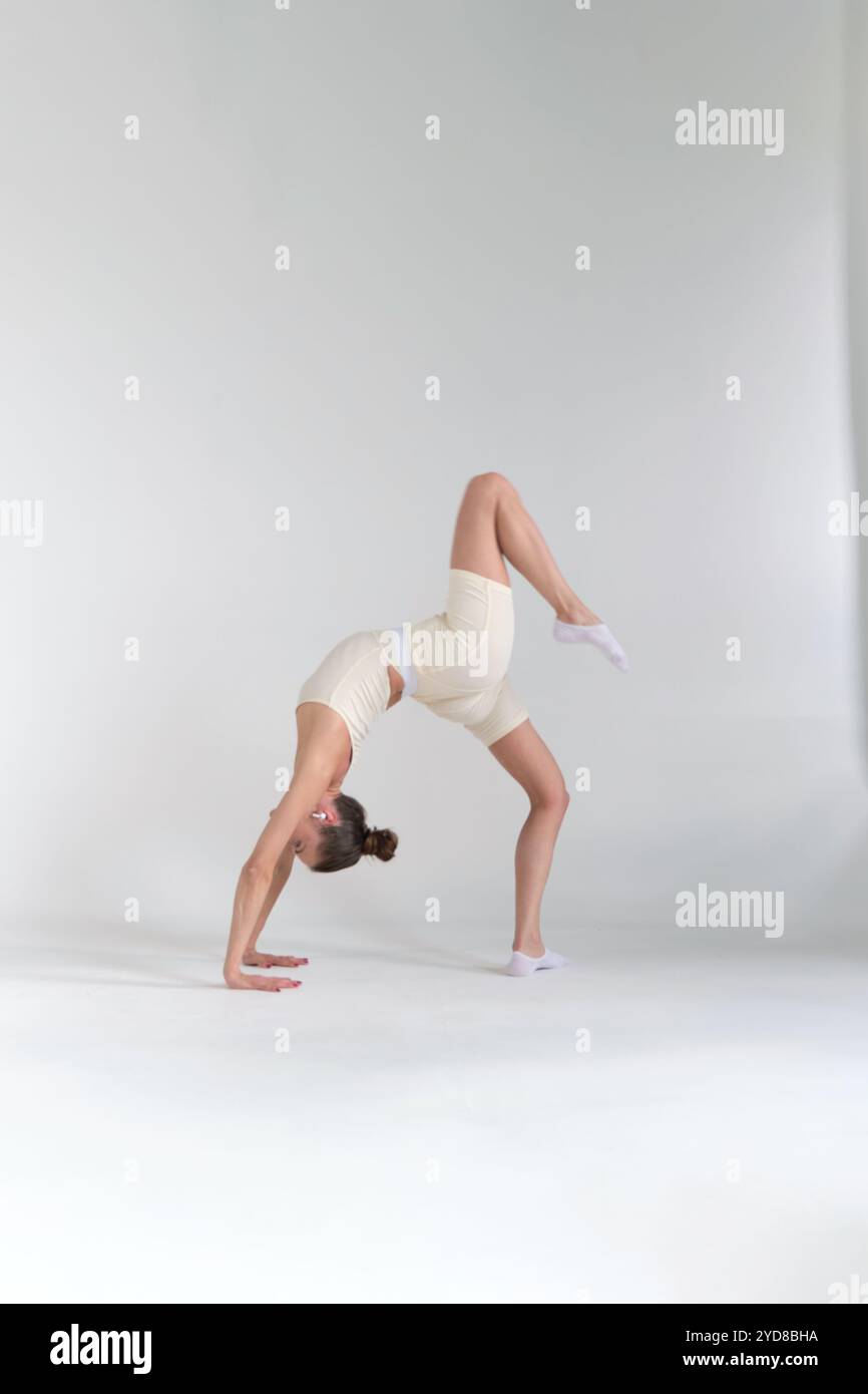 Woman performing a backbend with one leg lifted, showcasing strength ...