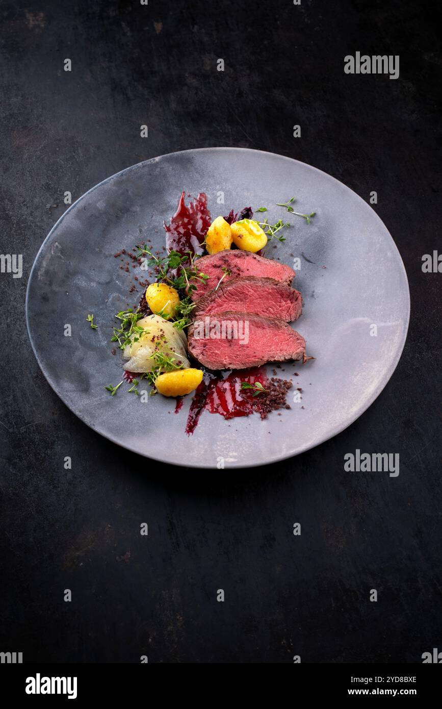 Traditional fried venison back filet with sliced pear Stock Photo - Alamy
