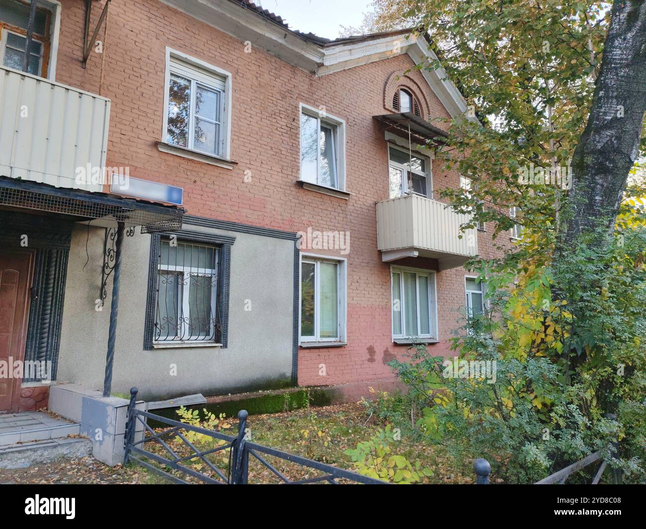 A modest residential building made of red brick, with balconies and a ...