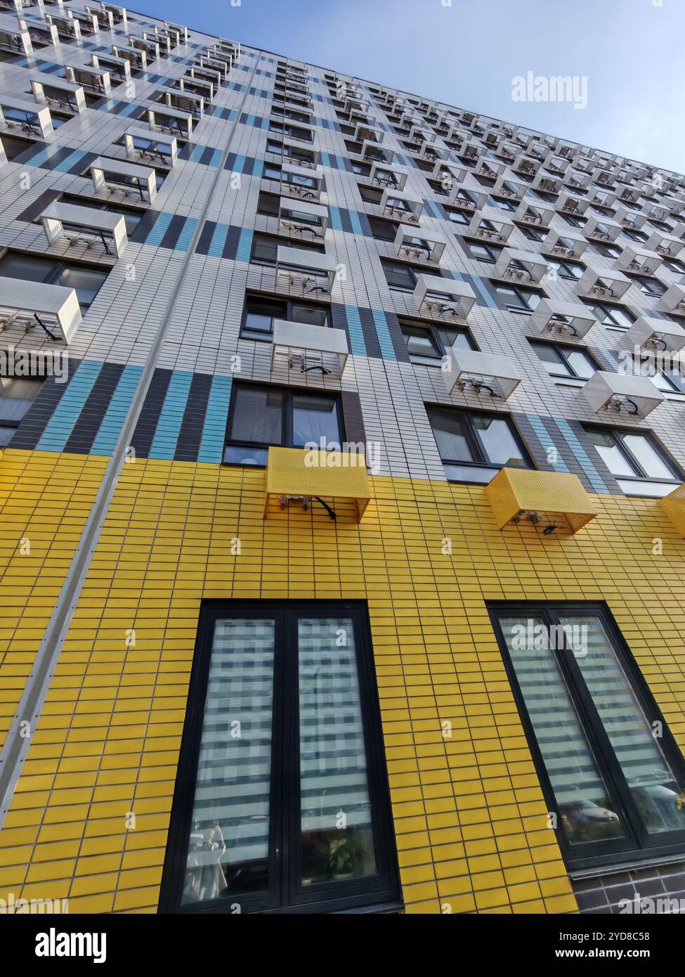 Two high-rise buildings featuring a dynamic contrast of yellow and ...