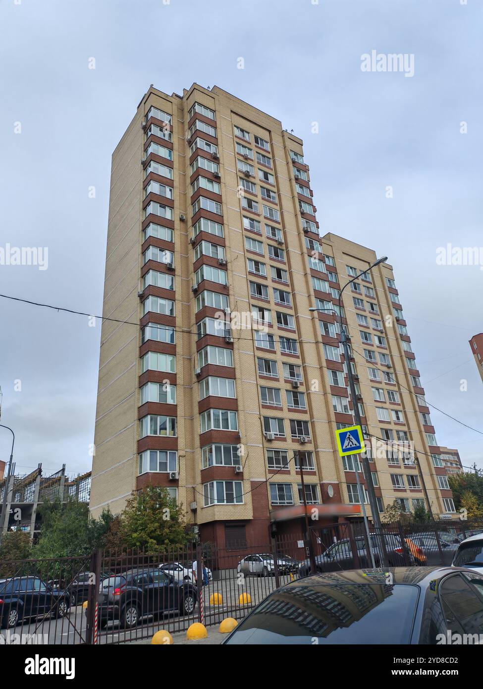 A pastel-colored high-rise residential building with curved balconies ...