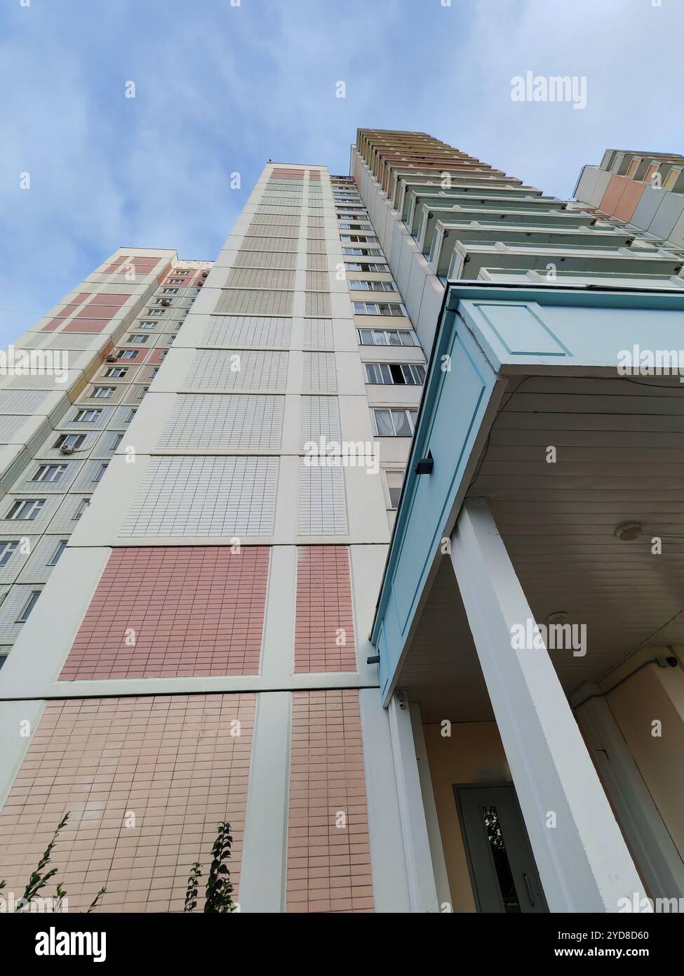 A towering residential building with pastel accents, featuring a wide ...