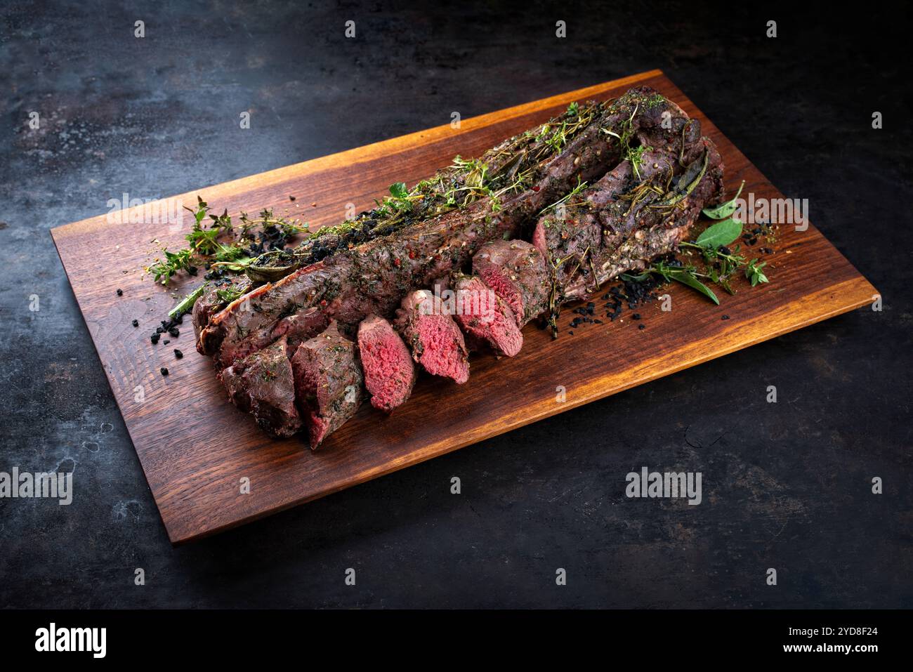 Traditionally roasted saddle of venison with fillet pieces and herbs ...