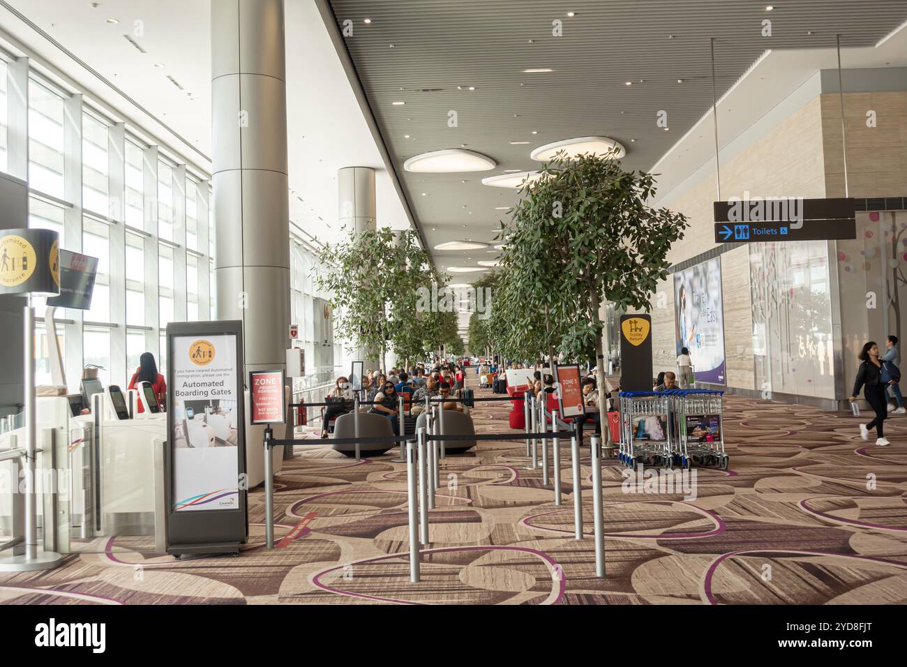 Passengers in a waiting zone in front of boarding gates, Singapore ...