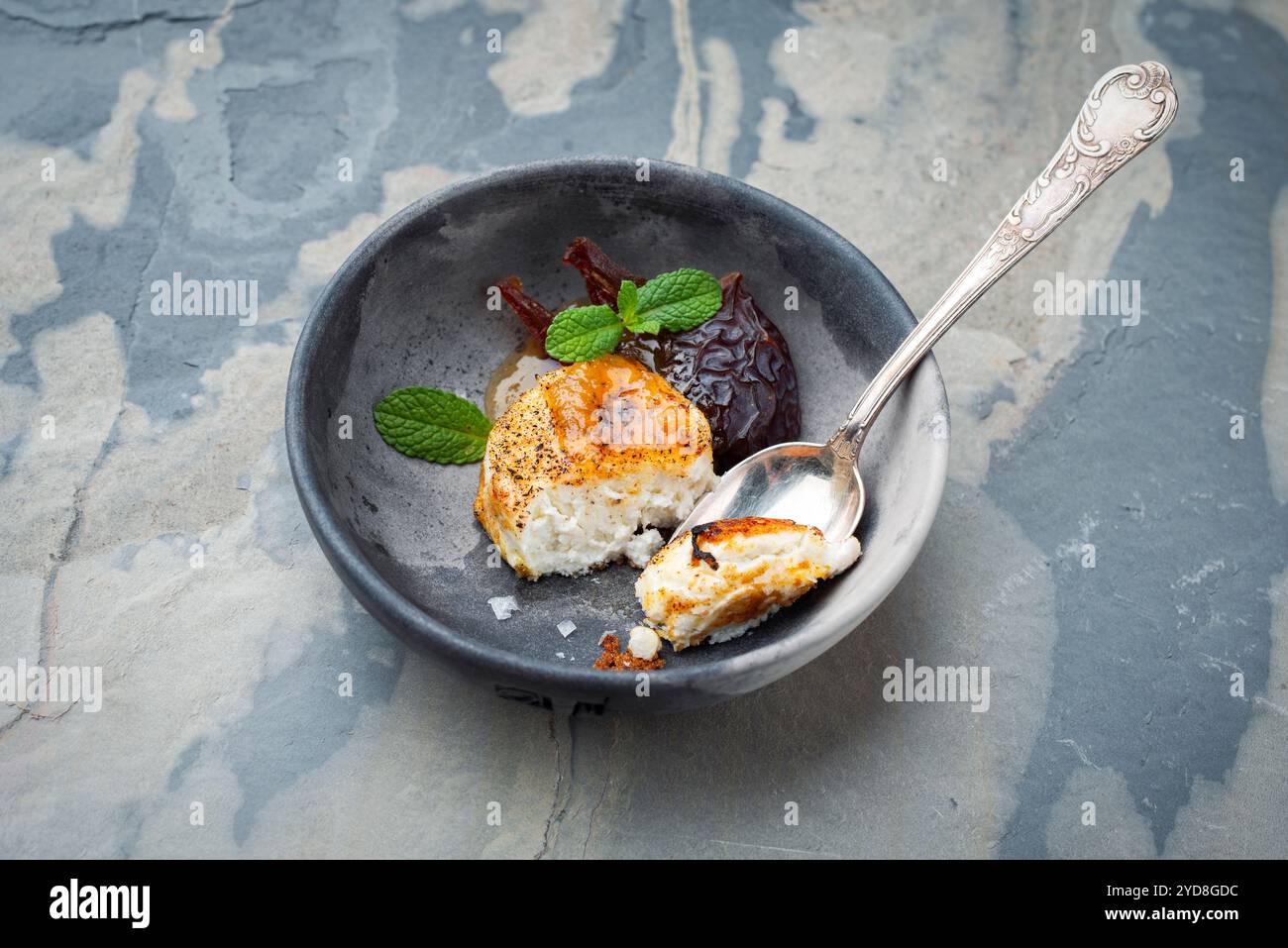 Traditional Greek goat's cheese gratinated with plums and salt served ...