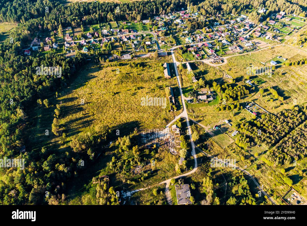 Aerial view of village outskirts with ruins of Soviet collective farm ...