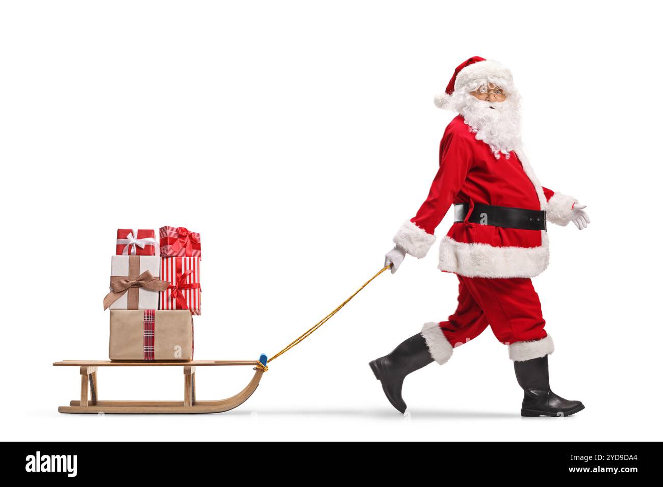 Santa Claus alking and pulling a wooden sled with presents isolated on ...