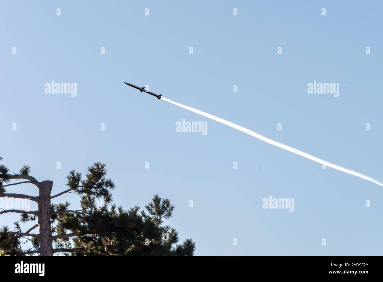 The rocket takes off into the sky, leaving behind a trail against the ...