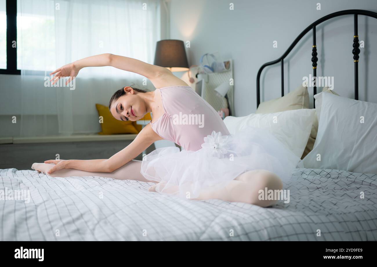 A girl ballet student, Warm up in bed in bedroom before practicing ...