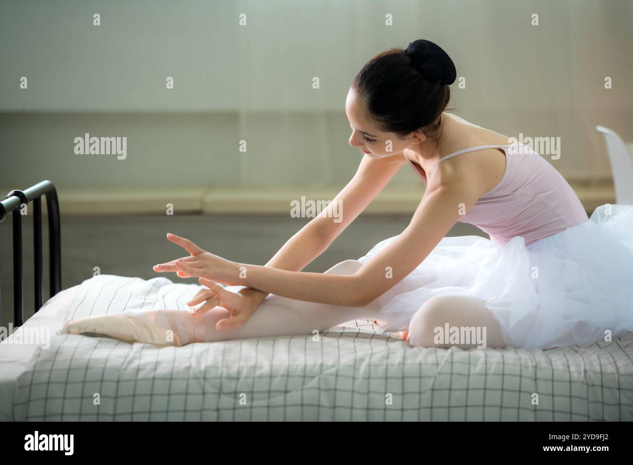 A girl ballet student, Warm up in bed in bedroom before practicing ...