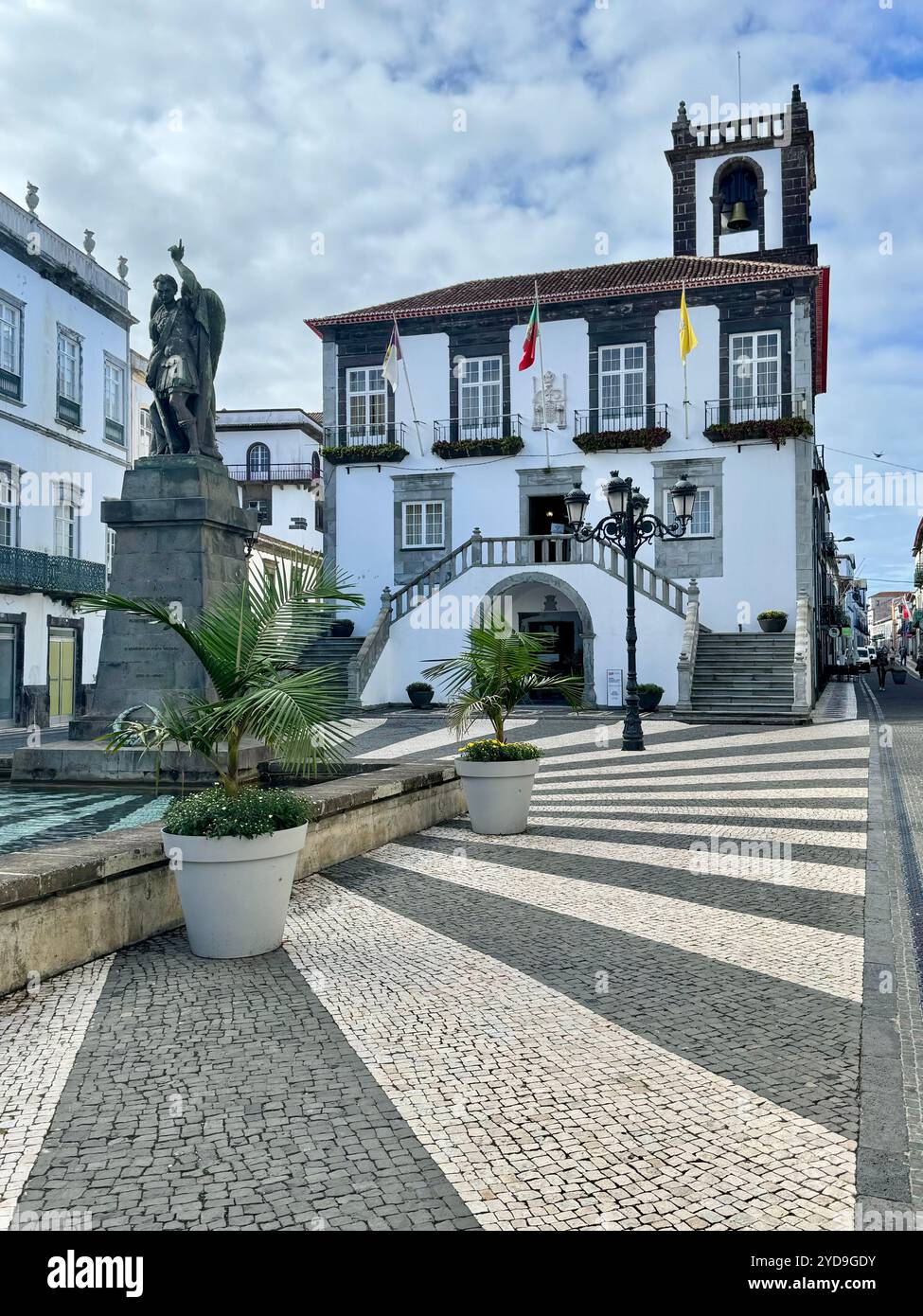 Statue fountain and historic municipal building on a patterned cobblestone square in Ponta ...