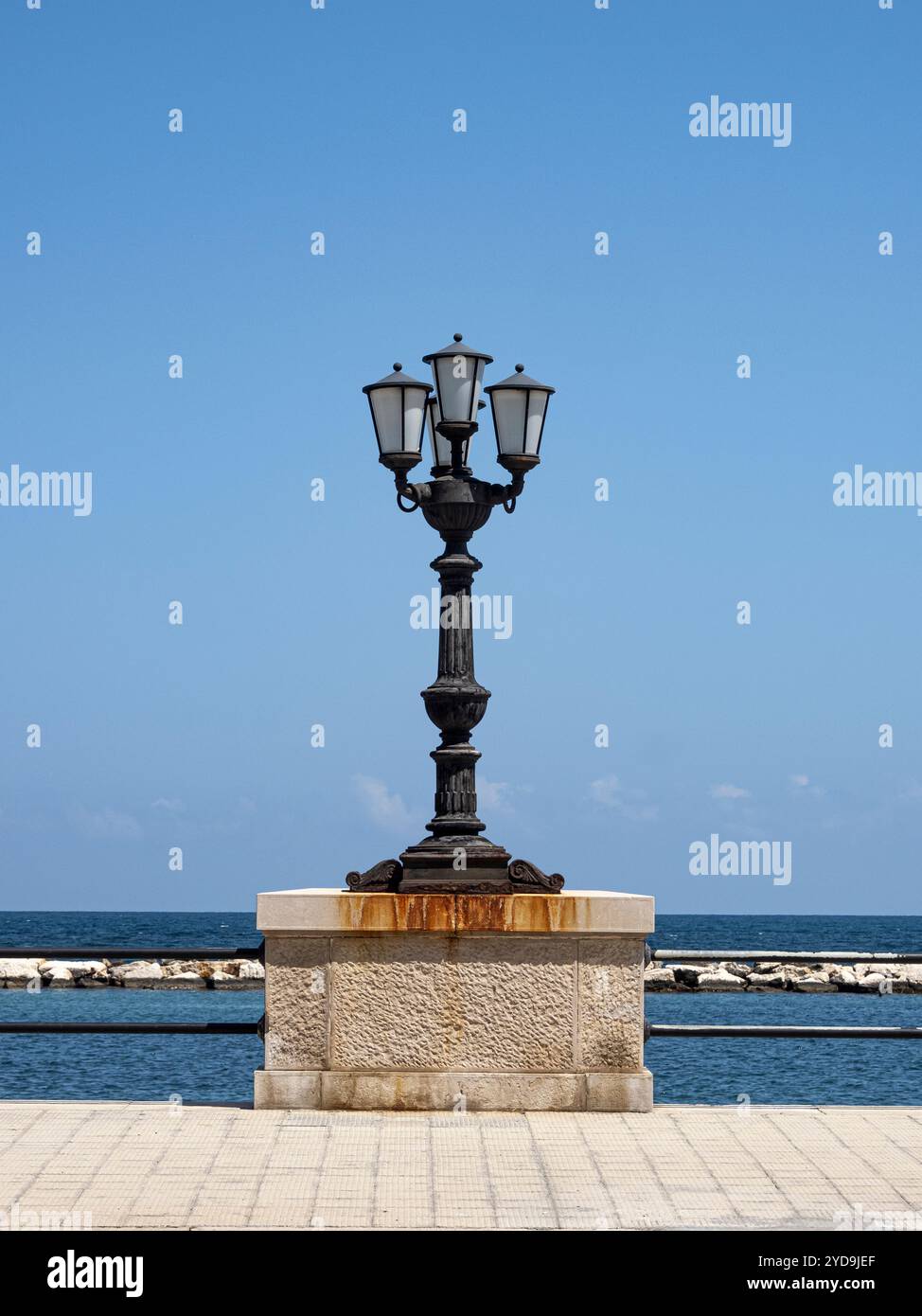 Single street lamp on the seaside promenade. Sea view, blue clear sky ...