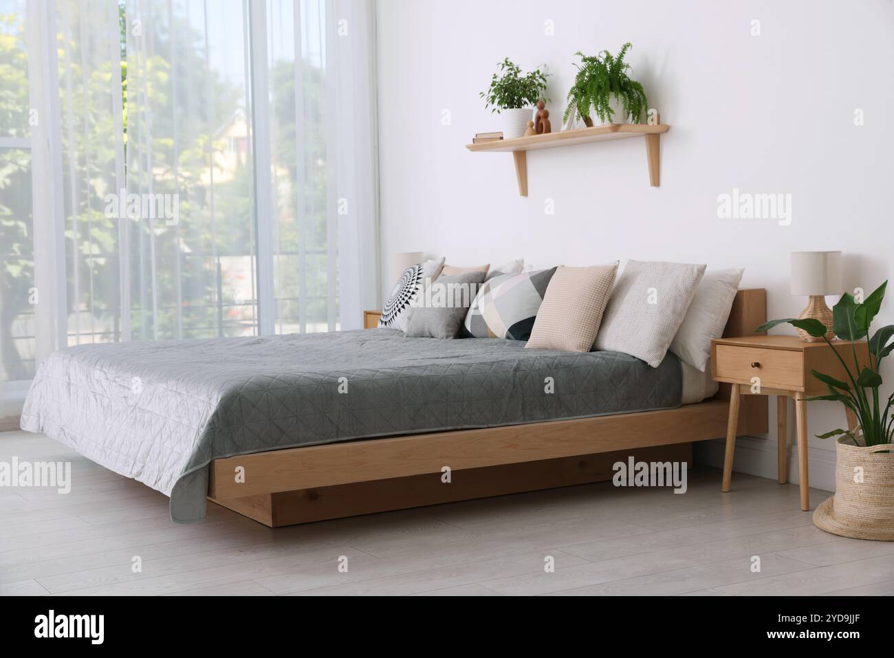 Large bed near window in room. Stylish bedroom interior Stock Photo - Alamy