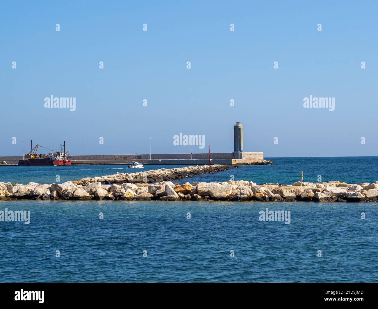 Stone breakwater and pier with a lighthouse Stock Photo - Alamy