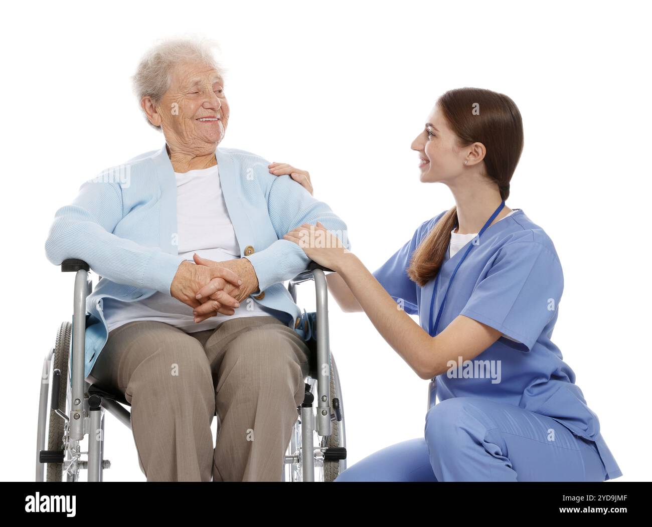 Caregiver assisting senior woman in wheelchair on white background ...