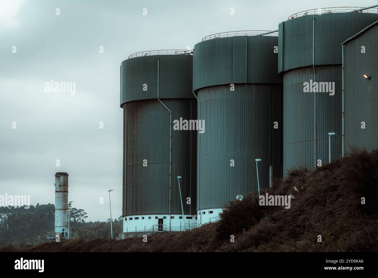 Industrial silos with corrugated metal walls, painted in a dark teal ...
