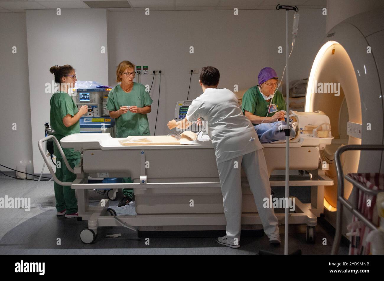 A medical team preparing a patient for a magnetic resonance imaging MRI scan. Medical team in a ...