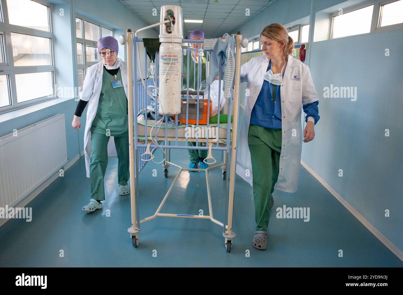 Doctors and nurses transporting a patient on a stretcher through a ...