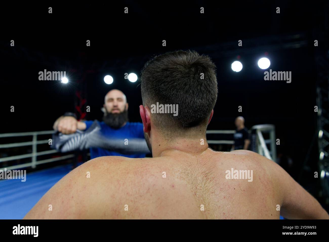 A weary boxer heeds their trainer's words of encouragement during a ...