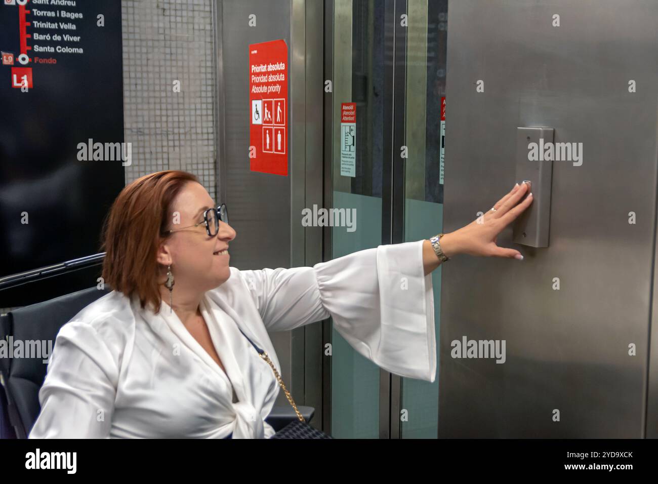 Woman in Wheelchair Pressing Elevator Button at Metro Stock Photo - Alamy