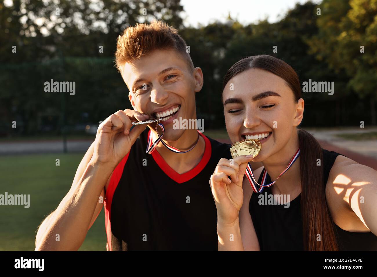 Happy winners with medals taking selfie at stadium Stock Photo - Alamy