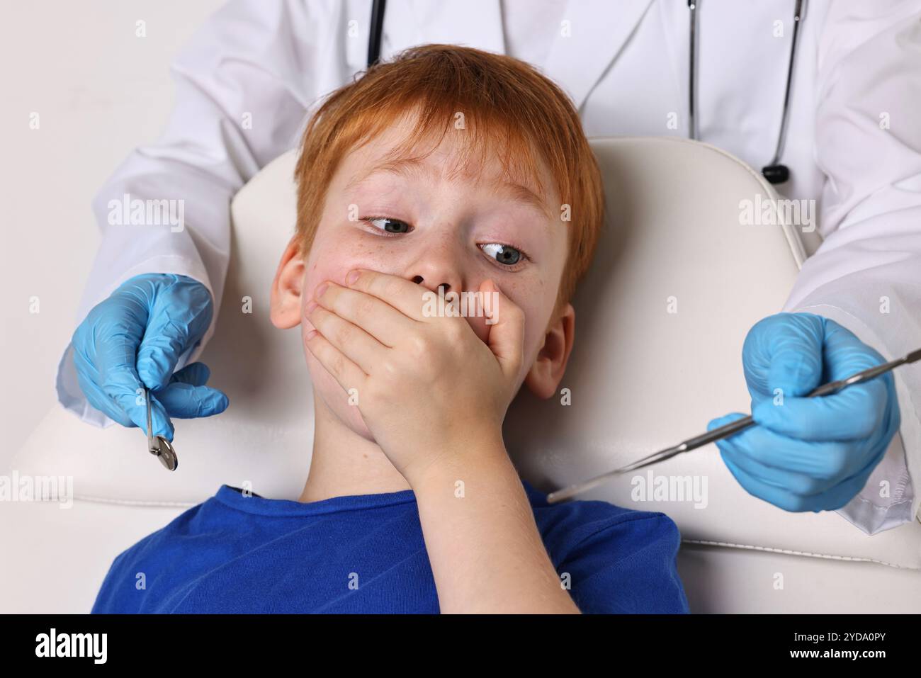 Dental phobia. Dentist working with scared little boy Stock Photo - Alamy