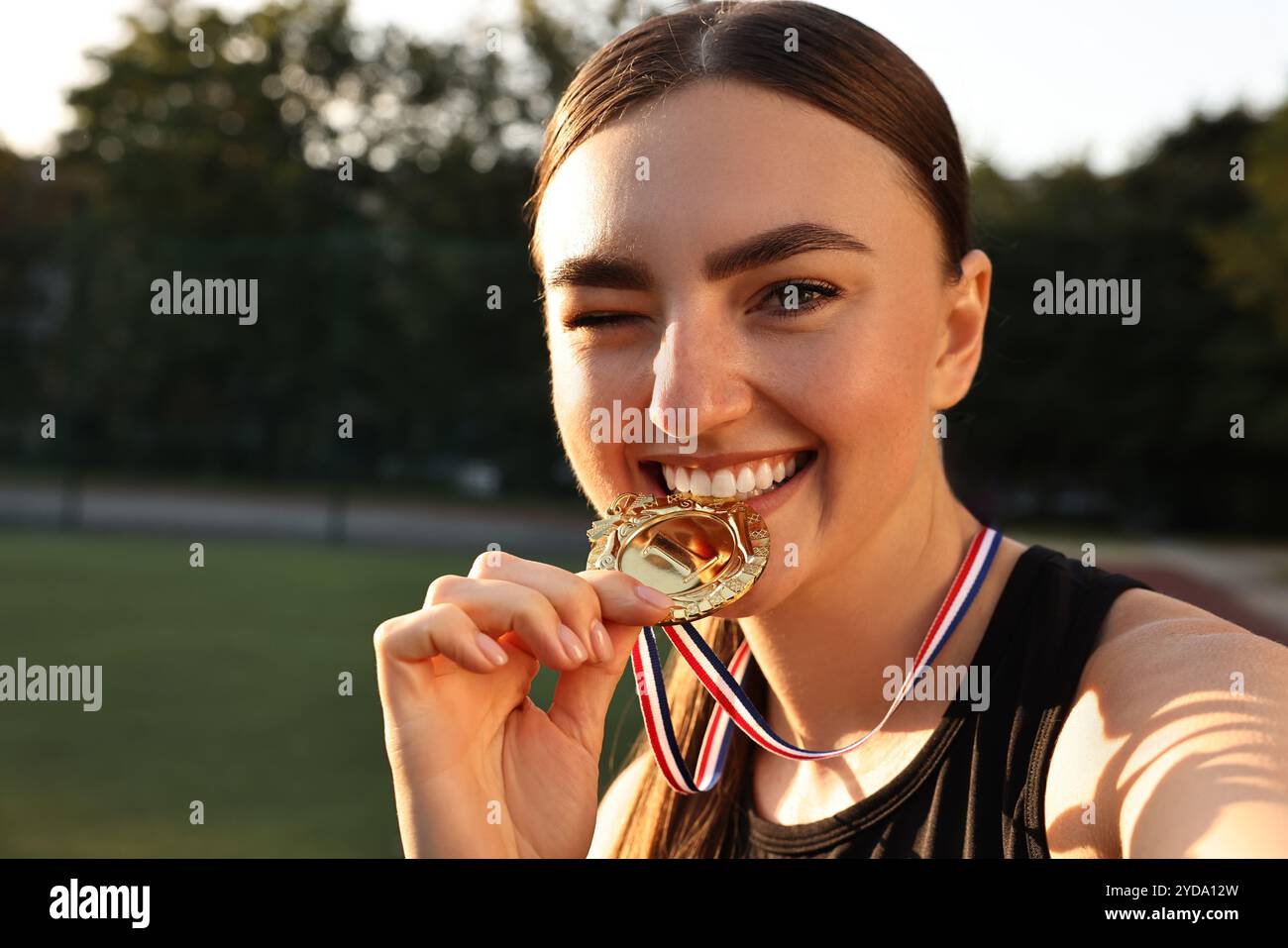 Happy winner with golden medal at stadium Stock Photo - Alamy