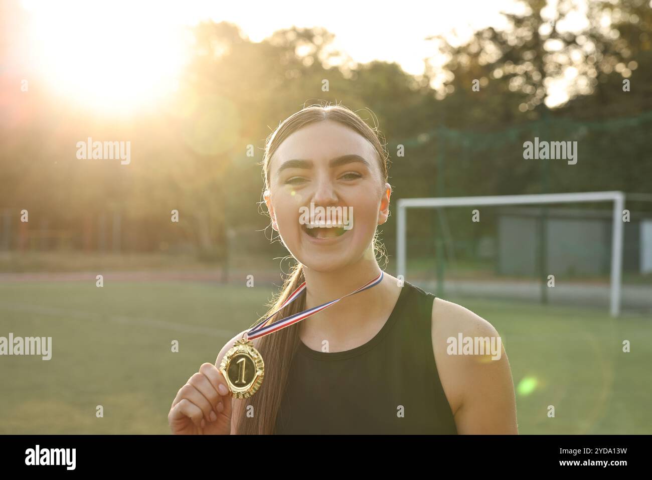 Happy winner with golden medal at stadium Stock Photo - Alamy