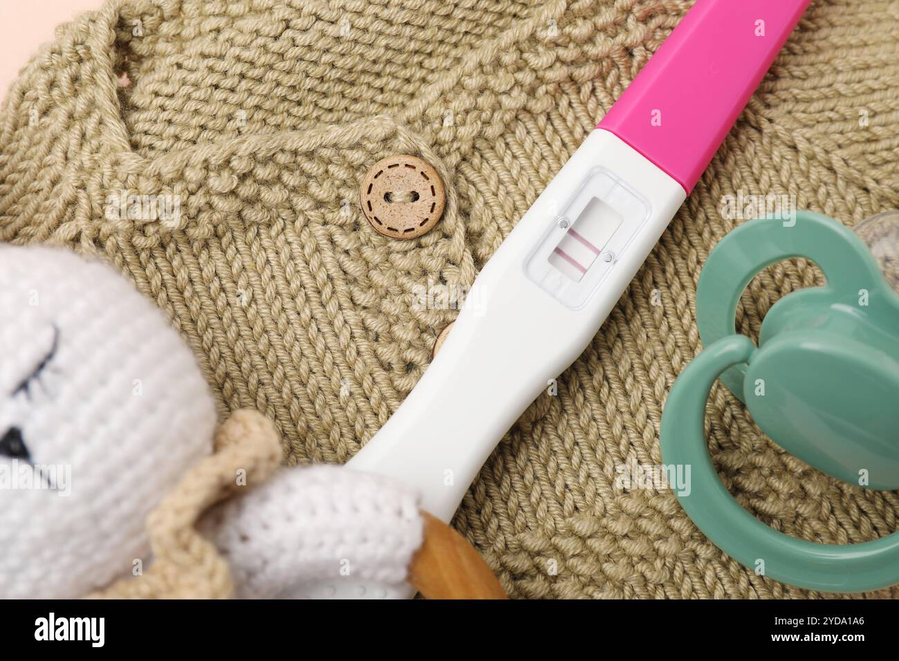 Pregnancy test, rattle, baby clothes and pacifier, closeup Stock Photo ...