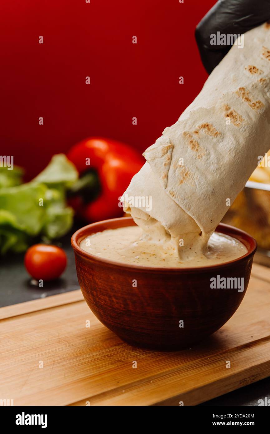 Dipping a wrap into creamy sauce, the perfect blend of flavors for food ...