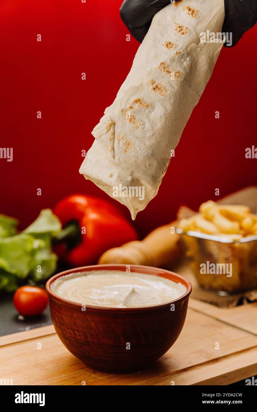 Dipping a wrap into creamy sauce, the perfect blend of flavors for food ...