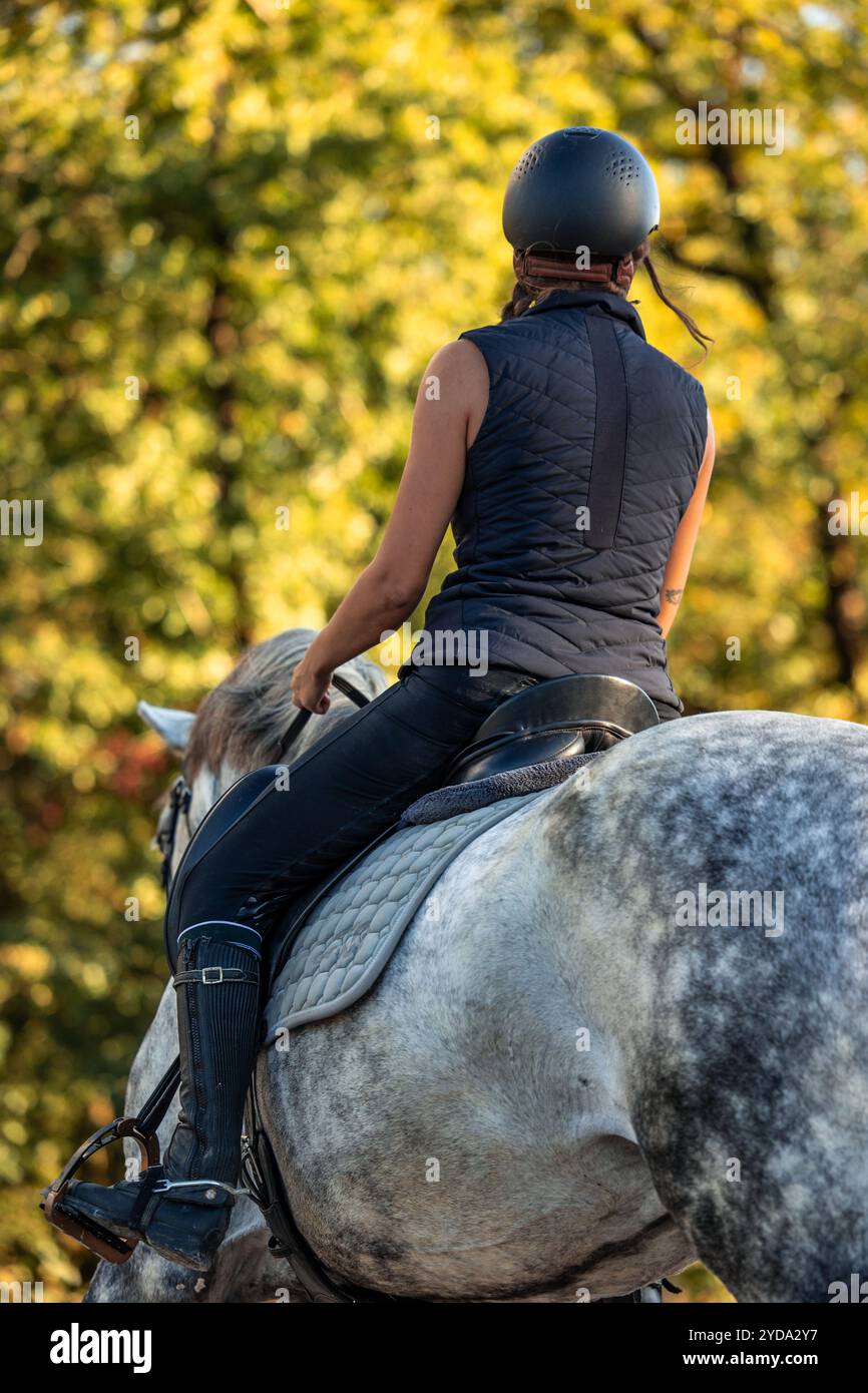 vertical close-up female rider in a helmet as she gracefully rides her ...