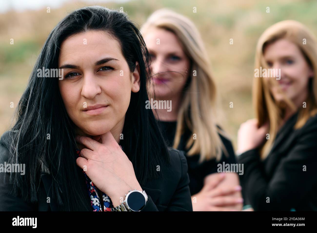 A diverse team of professional women clad in sleek black suits takes a ...