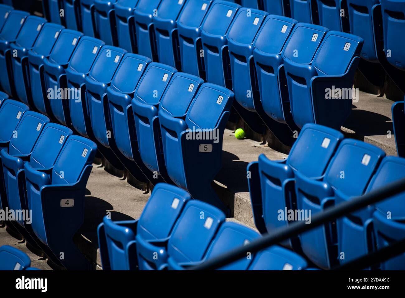 Empty rows of blue seats in a stadium seating in a tennis court. A ...