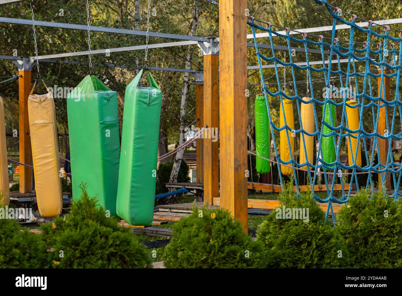 Colorful obstacle course with hanging cushions and net climbing area in ...