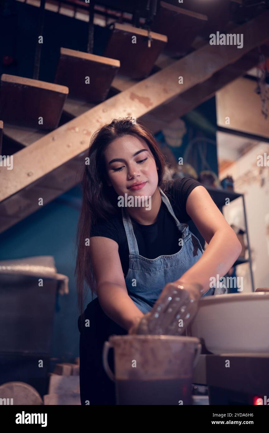 Pottery artist, Young female making a piece of clay molding calmly and ...