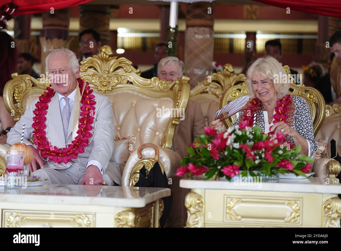 King Charles III and Queen Camilla laughing during a farewell ceremony at Siumu Village on the ...