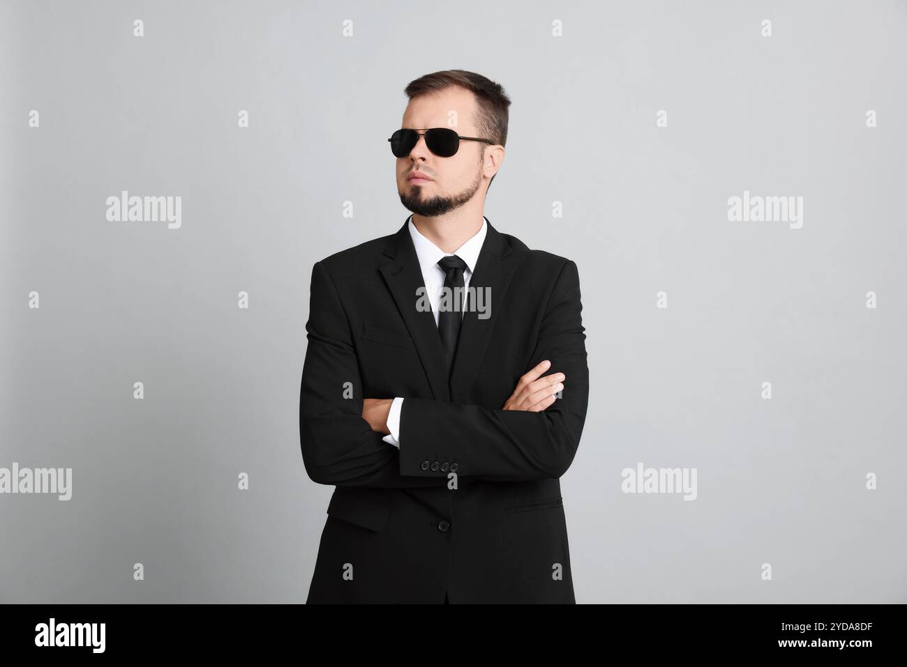 Young bodyguard in suit and sunglasses on grey background Stock Photo ...