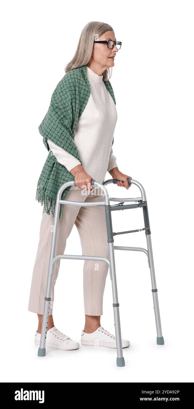 Senior woman using walking frame on white background Stock Photo - Alamy