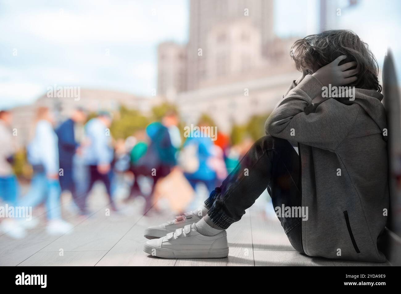 Loneliness. Sad boy sitting in room and crowded street, double exposure ...
