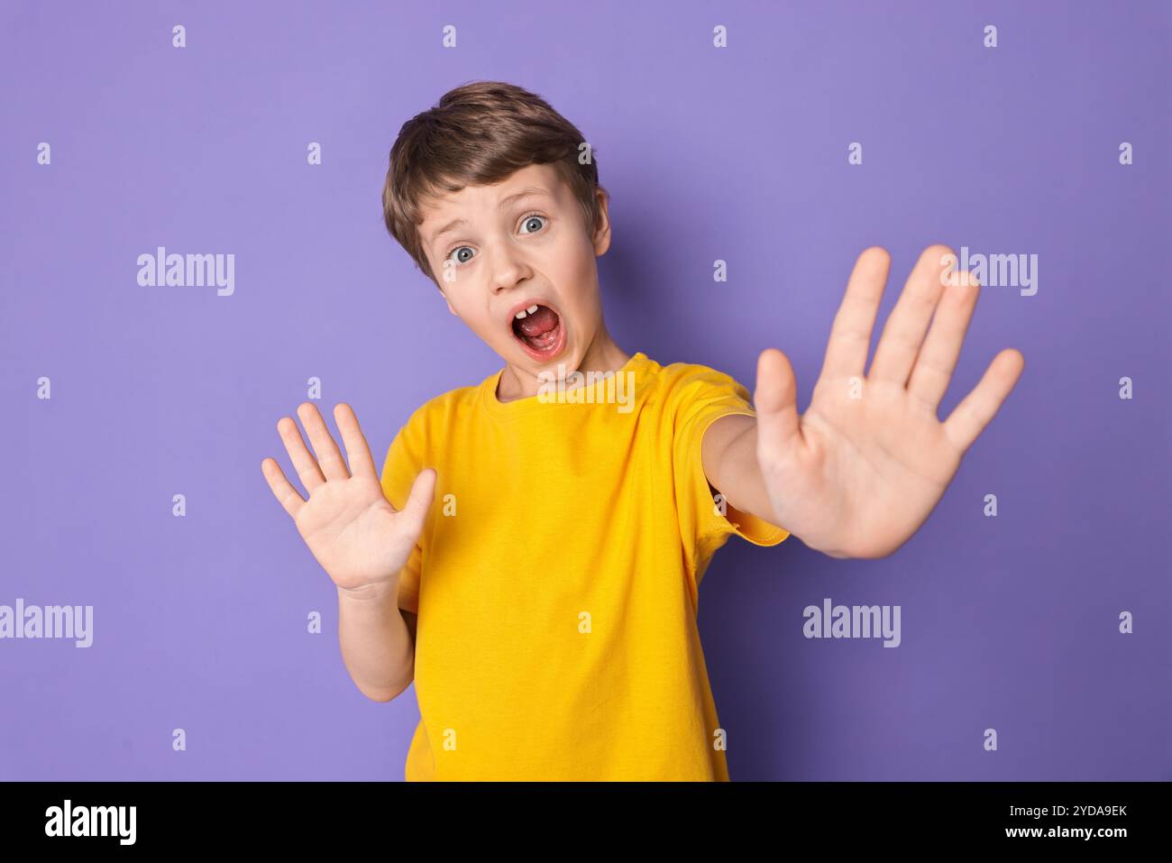 Portrait of scared little boy on violet background Stock Photo - Alamy