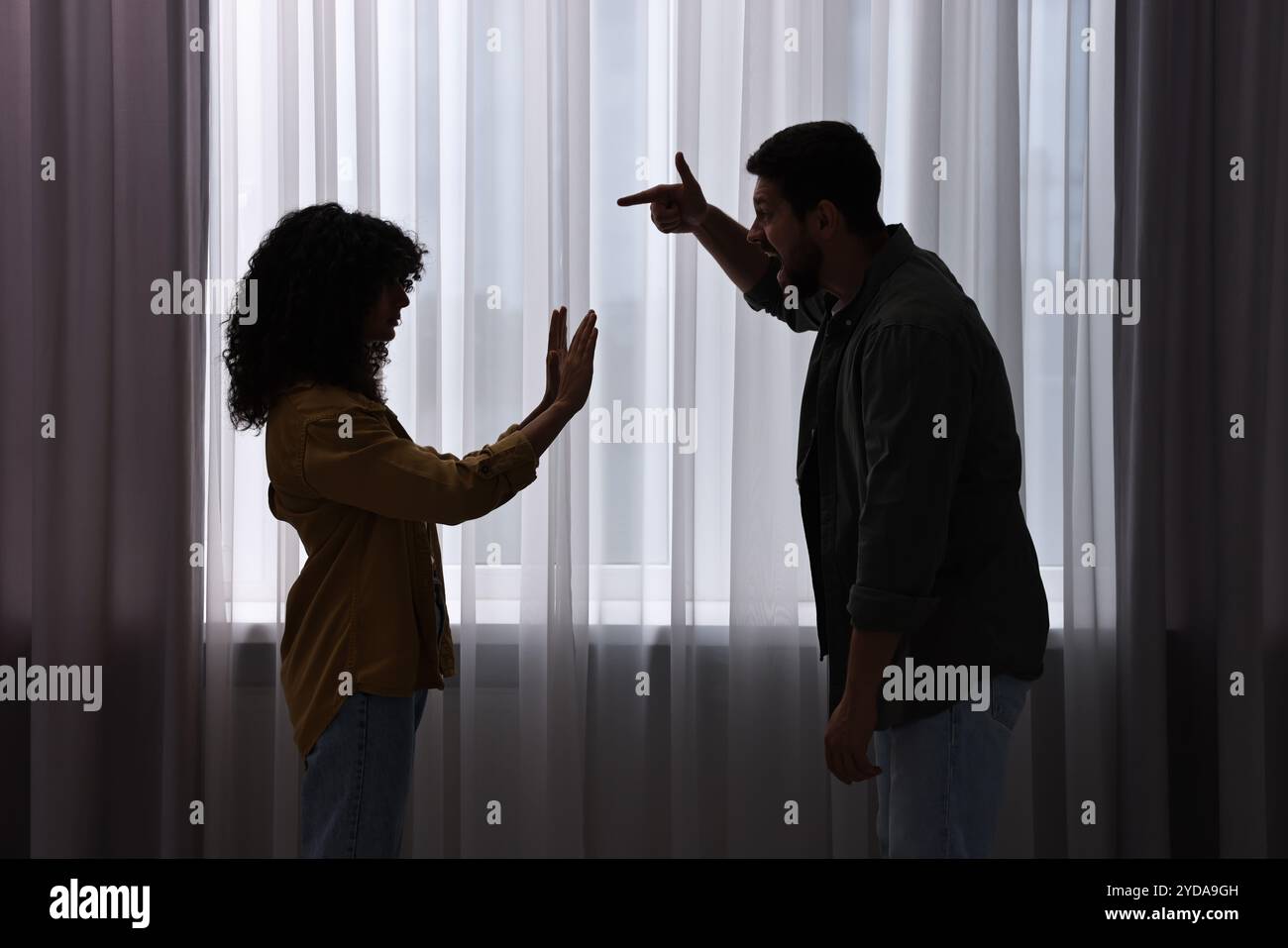 Emotional couple arguing indoors at night. Relationship problems Stock ...