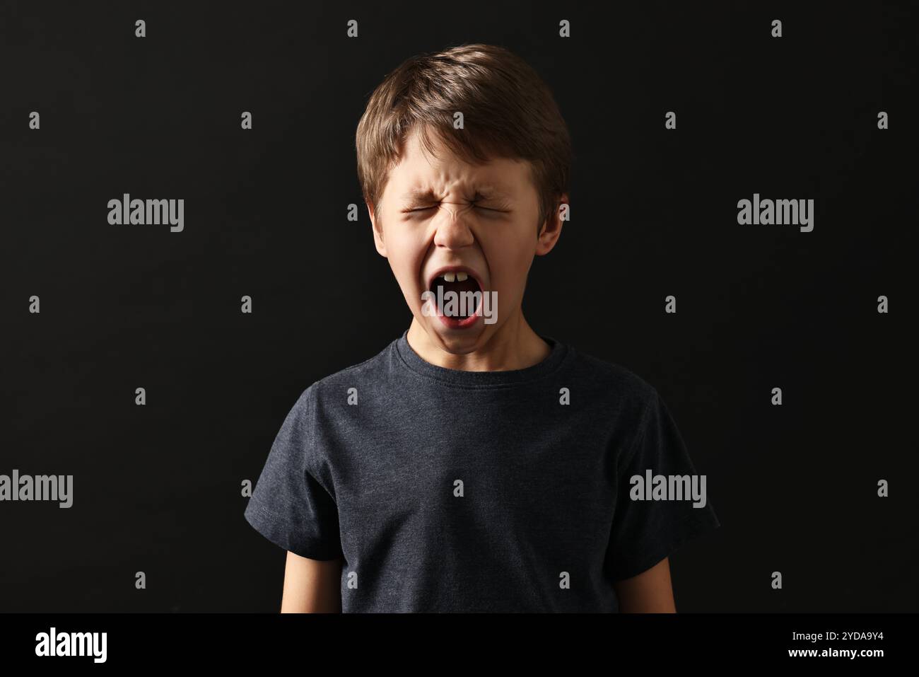 Scared little boy screaming on black background Stock Photo - Alamy