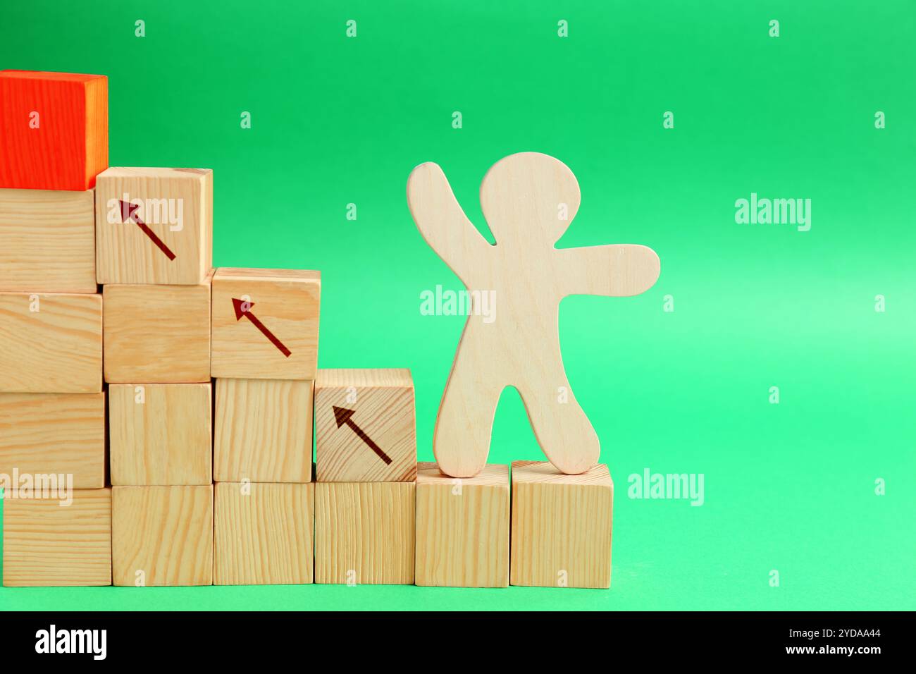 Human figure on stair made of wooden blocks against green background ...